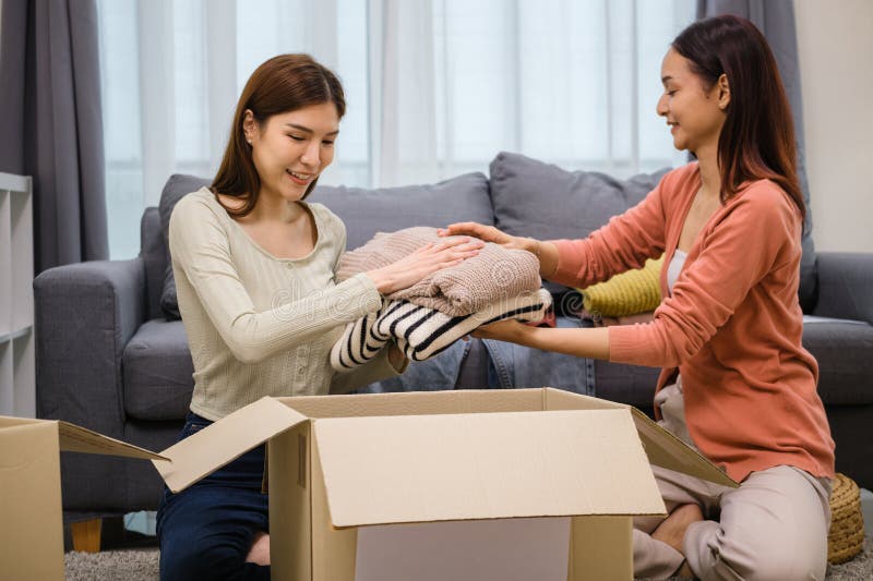 Group of Friend Sorting and Packing Clothes into a Donation Box ...