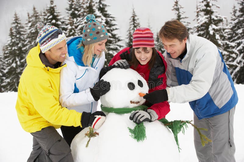 Group of Friends Building Snowman on Ski Holiday Stock Photo - Image of ...