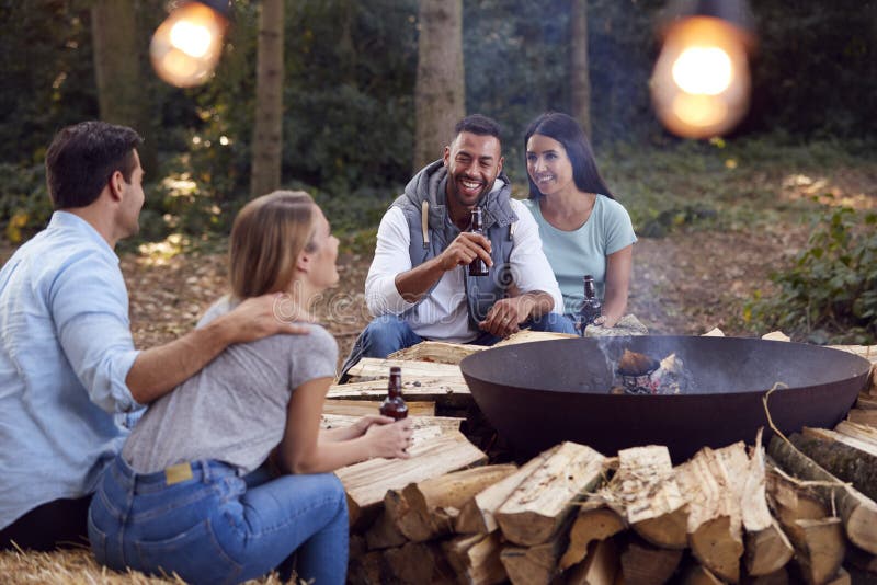 Group of Friends Camping Sitting by Bonfire in Fire Bowl Drinking Beer ...