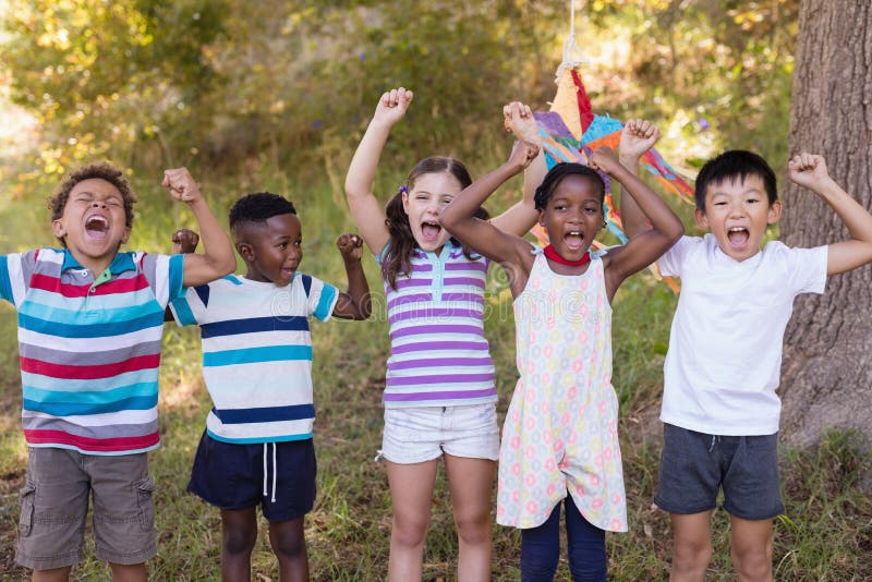 Group of Friends Cheering while Standing on Grassy Field Stock Photo ...