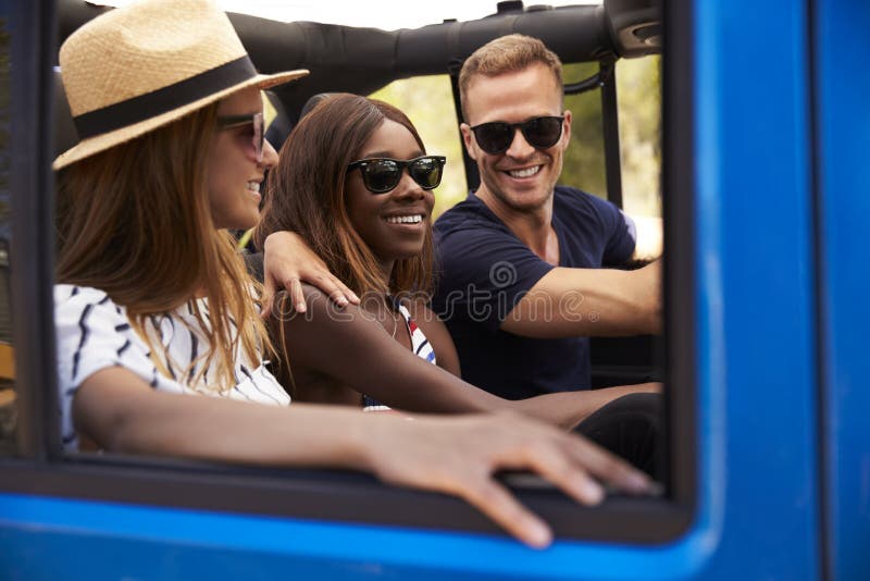 Group of Friends Driving Open Top Car on Country Road Stock Photo ...