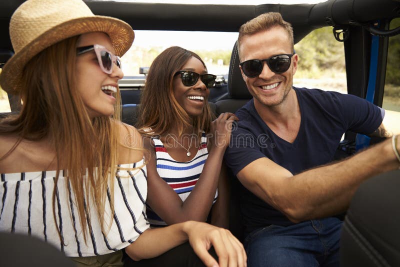 Group of Friends Driving Open Top Car on Country Road Stock Photo ...