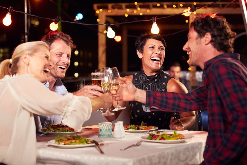 Group of Friends Eating Dinner at Rooftop Restaurant Stock Photo ...