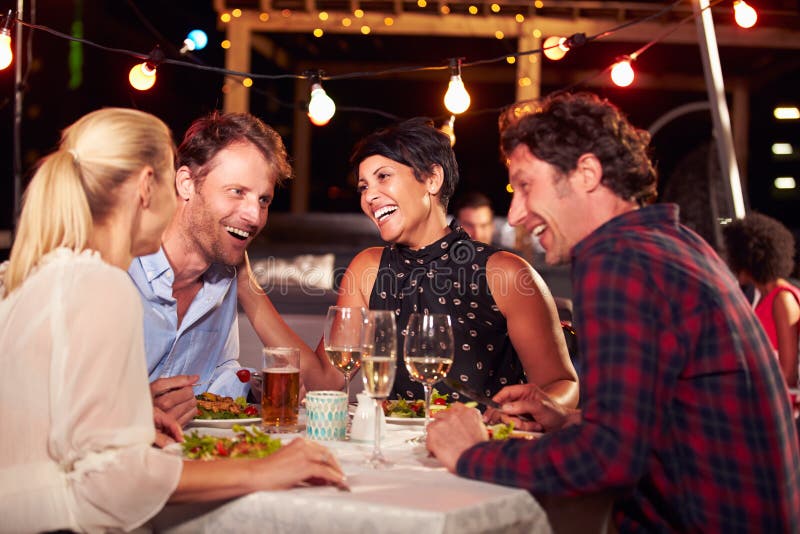 Group of Friends Eating Dinner at Rooftop Restaurant Stock Photo ...