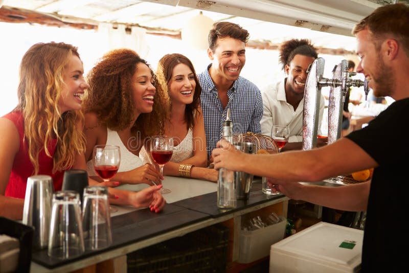 Three Female Friends Enjoying Drink at Outdoor Bar Stock Photo - Image ...