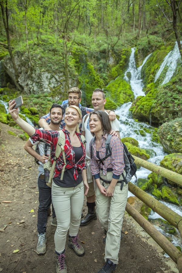 Group of Friends Having Fun and Taking Selfies in Front of a Waterfall ...