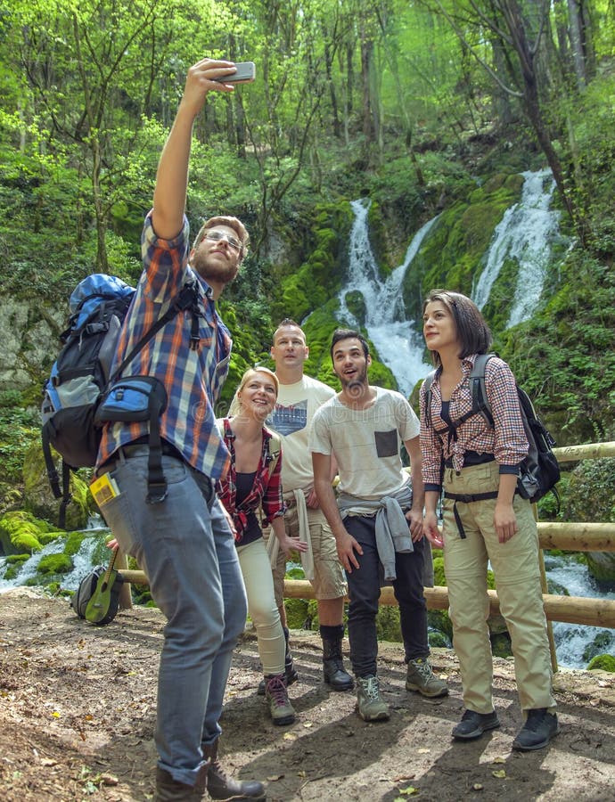 Group of Friends Having Fun and Taking Selfies in Front of a Waterfall ...