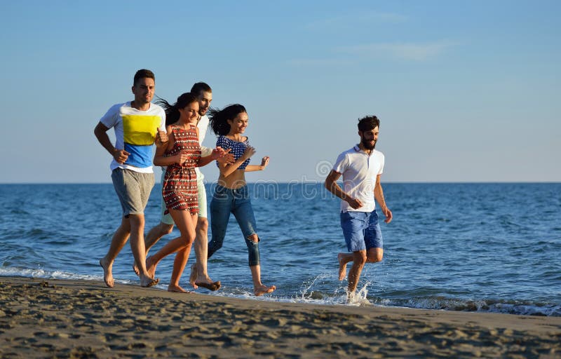 Group of Friends Having Fun Walking Down the Beach at Sunset Stock ...