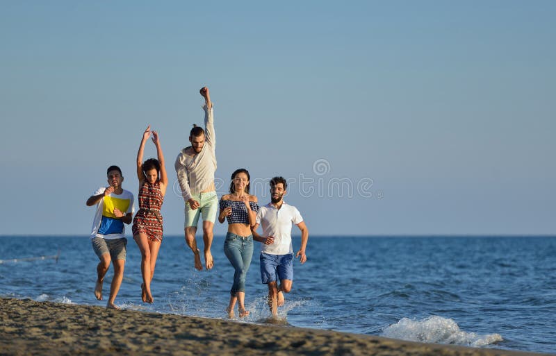 Group of Friends Having Fun Walking Down the Beach at Sunset Stock ...
