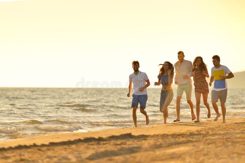 Group of Friends Having Fun Walking Down the Beach at Sunset Stock ...
