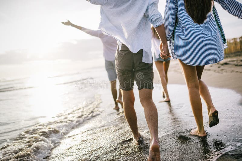 Group of Friends Having Fun and Walking on the Beach at Sunset Stock ...