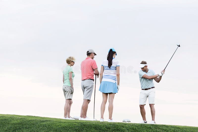 Group of Friends Looking at Man Playing Golf Against Clear Sky Stock ...