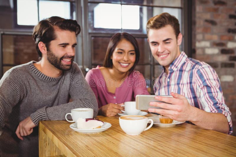 Group of Friends Looking at a Smartphone Stock Photo - Image of group ...