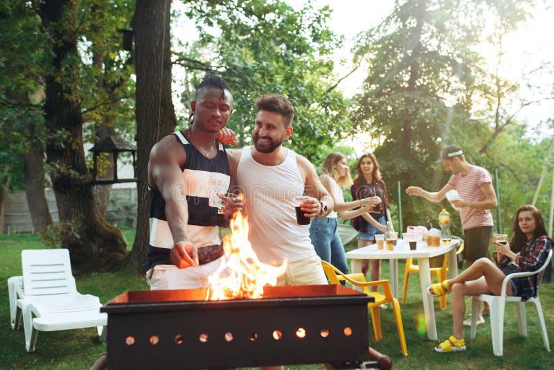 Group of Friends Making Barbecue in the Backyard. Concept about Good ...