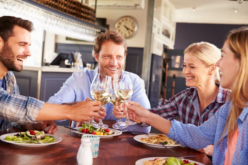 A Group of Friends Making a Toast at a Restaurant, Portrait Stock Image ...