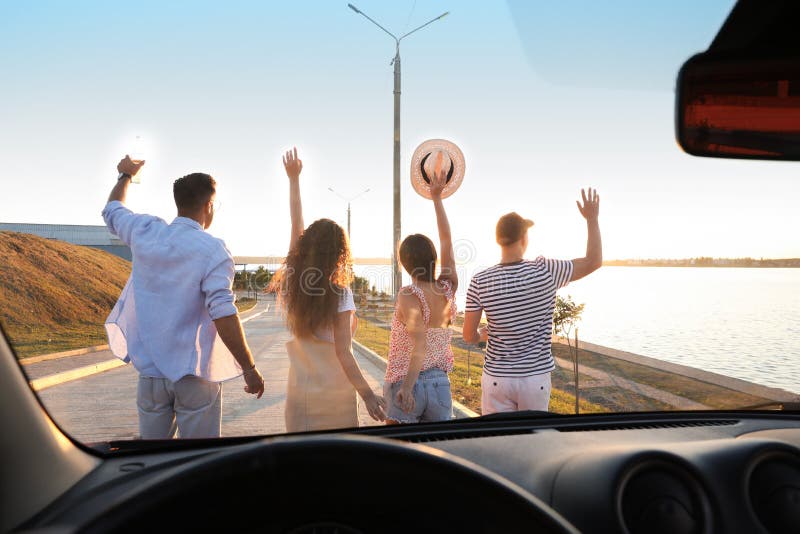 Group of Friends Near Car Outdoors at Sunset, View through Windshield ...