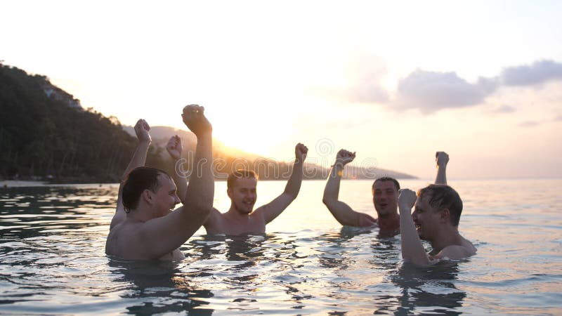 Group of Friends Play in the Sea at Sunset Together on Beach Vacation ...