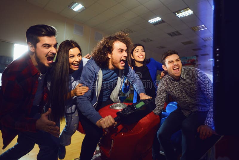 A Group of Friends Playing Arcade Machine. Stock Photo - Image of happy ...