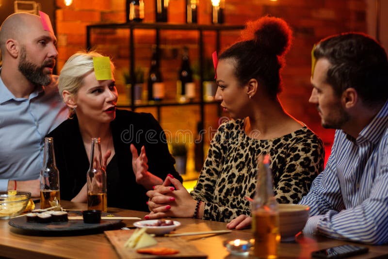 Group of Friends Playing Sticky Head Game Behind Bar Counter in a Cafe ...