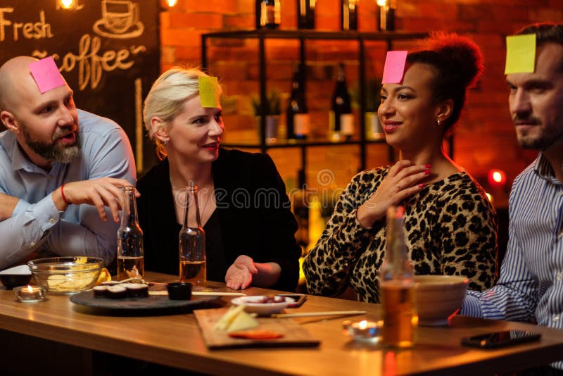 Group of Friends Playing Sticky Head Game Behind Bar Counter in a Cafe ...