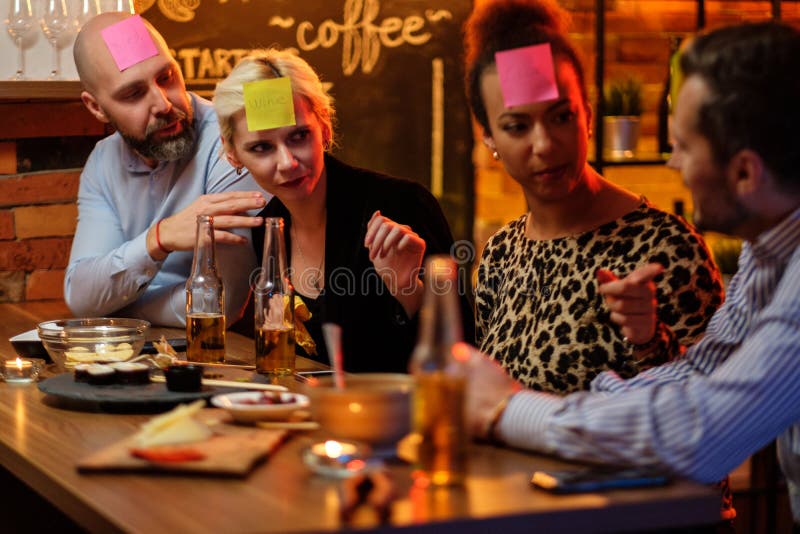 Group of Friends Playing Sticky Head Game Behind Bar Counter in a Cafe ...