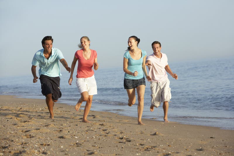 Group of Friends Running Along Beach Stock Image - Image of friends ...