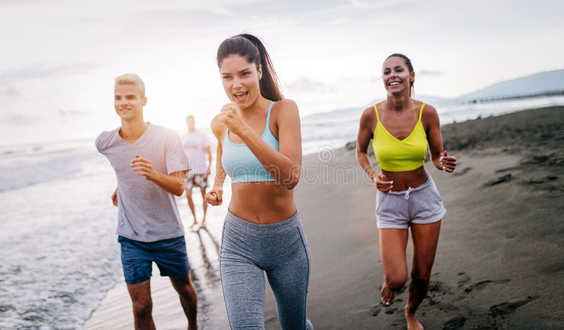 Group of Friends Running at the Beach on Beautiful Summer Sunset Stock ...