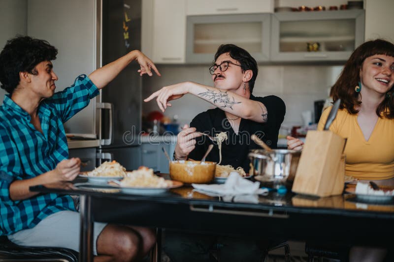 Friends Enjoying Pasta in a Lively Kitchen Setting Stock Image - Image ...