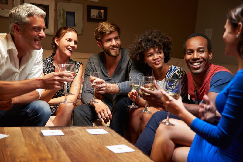 Group of Friends Sitting Around a Table at House Party Stock Photo ...