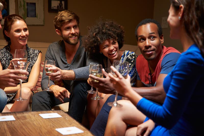 Group of Friends Sitting Around a Table at House Party Stock Image ...