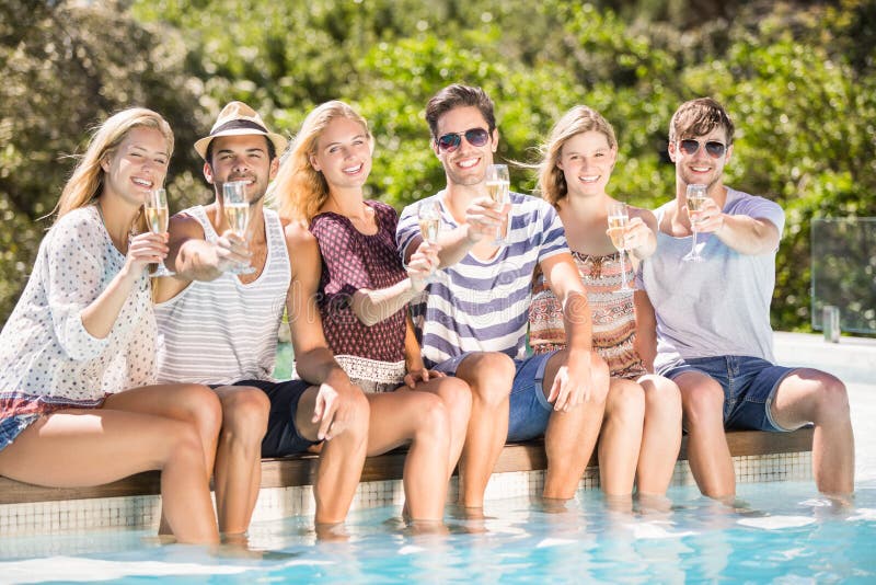 Group of Friends Sitting at Poolside with Glass of Champagne Stock ...
