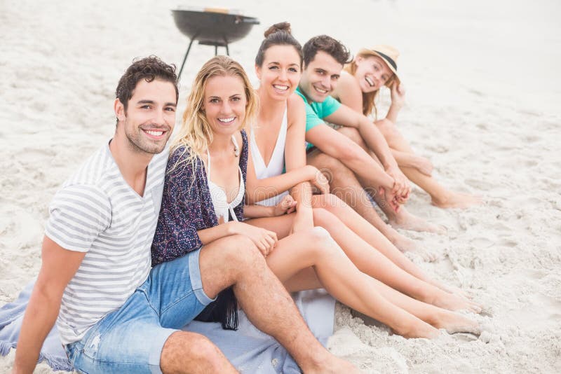 Group of Friends Sitting Side by Side on the Beach Stock Photo - Image ...