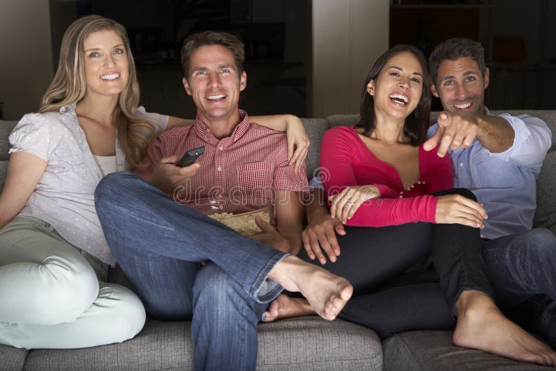 Group of Friends Sitting on Sofa Watching TV Together Stock Photo ...