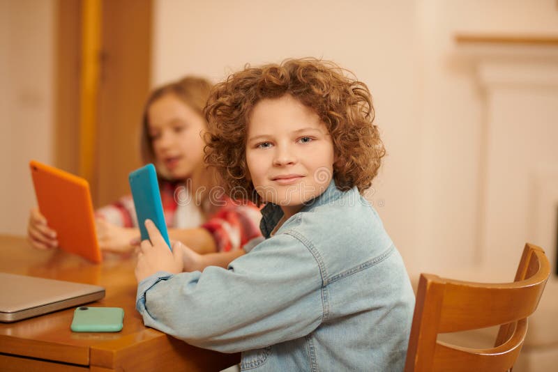 A Group of Friends Sitting at the Table and Spending Time on Internet ...