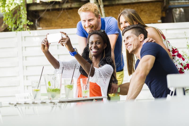 A Group of Friends Sitting a Table and Talking Smiling while Ta Stock ...