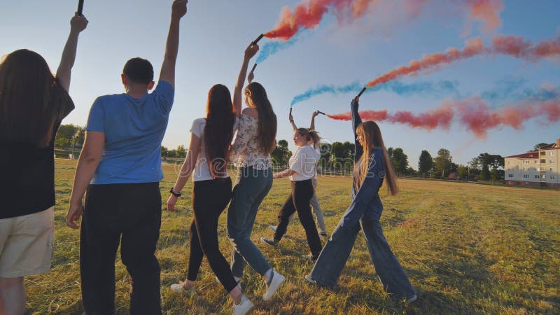 A Group of Friends Spraying Multi-colored Smoke at Sunset. Stock Photo ...