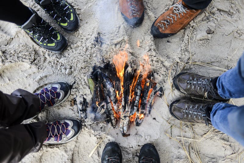 A Group of Friends Standing Around a Fire on a Beach Stock Photo ...