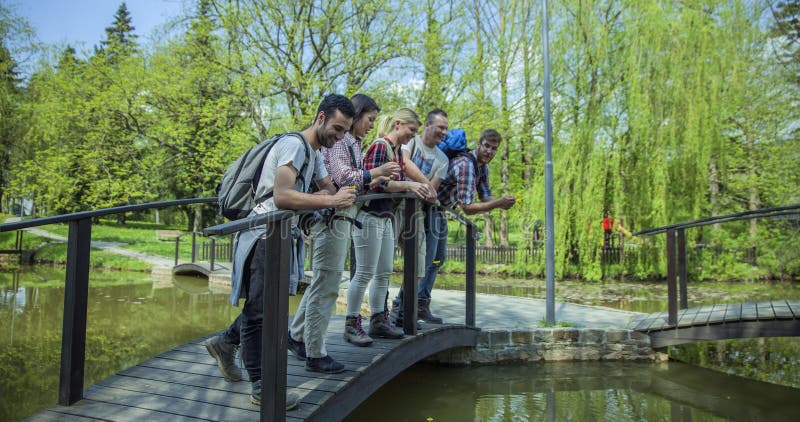 Group of Friends Standing on a Small Bridge in a Park on a Sunny Day ...