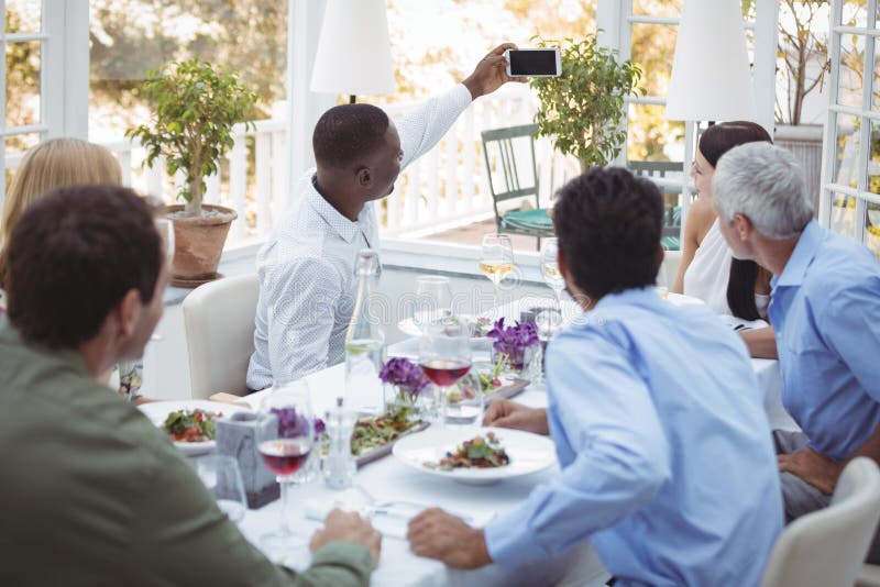 Group of Friends Taking Selfie on Mobile Phone during Lunch Stock Photo ...