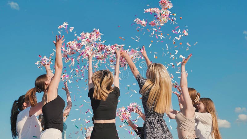 Group of Friends Throwing Confetti in the Air while Partying Outdoors ...