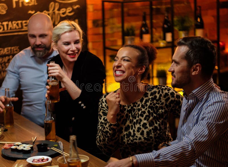 Group of Friends Watching Tv in a Cafe Behind Bar Counter Stock Photo ...
