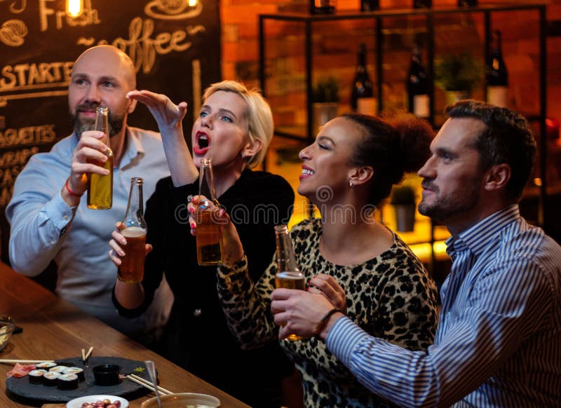 Group of Friends Watching Tv in a Cafe Behind Bar Counter Stock Photo ...