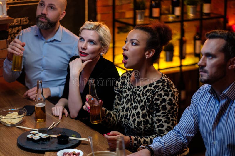 Group of Friends Watching Tv in a Cafe Behind Bar Counter Stock Photo ...