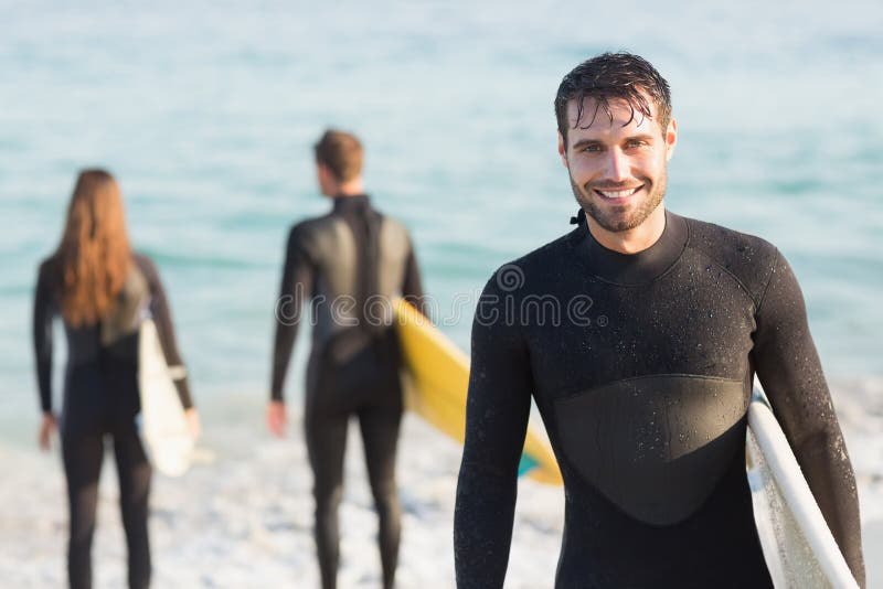Group of Friends on Wetsuits with a Surfboard on a Sunny Day Stock ...