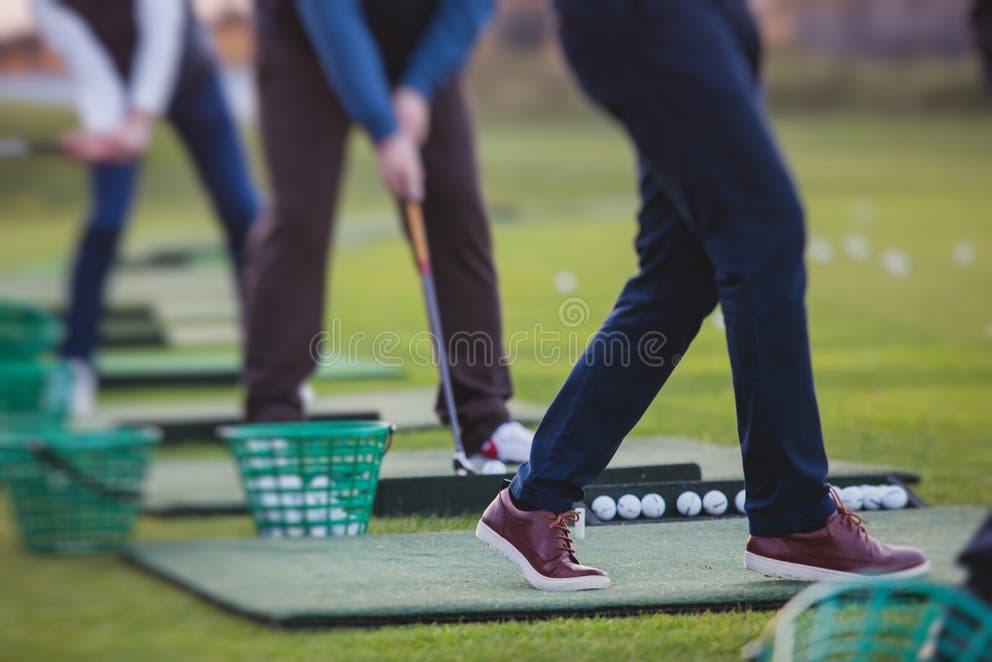 Group of Golfers Practicing and Training Golf Swing on Driving Range ...