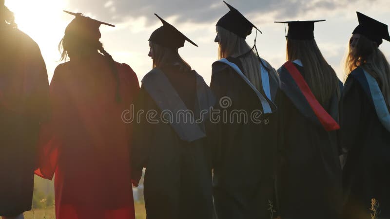 Group of Graduated Students Wearing Cap and Gown Looking at the Sunset ...