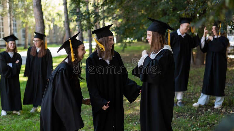 A Group of Graduates in Robes Congratulate Each Other on Their ...