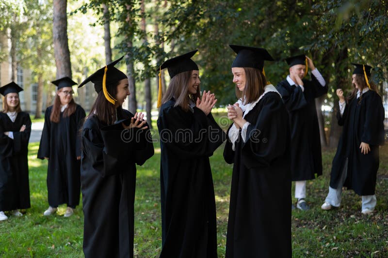 A Group of Graduates in Robes Congratulate Each Other on Their ...