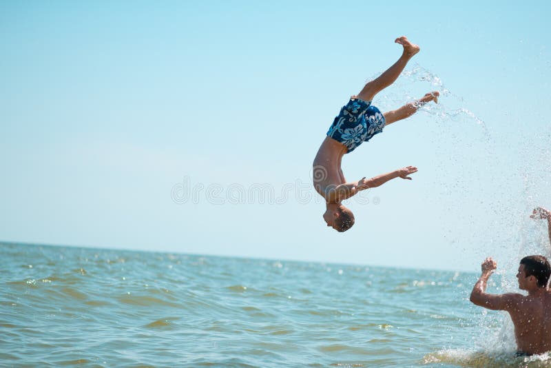 Group of Guys Standing in the Sea Tossed Up Man Stock Image - Image of ...