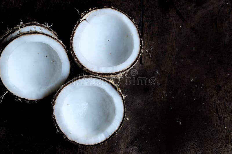 A Group of a Half Cut of Coconuts on Old Wooden Table with Dark ...